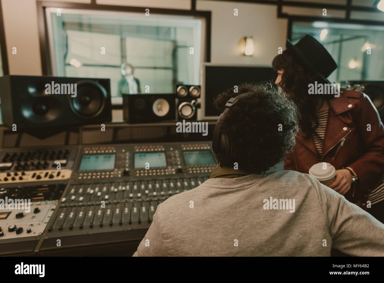 sound producers looking at singer at recording studio Stock Photo - Alamy
