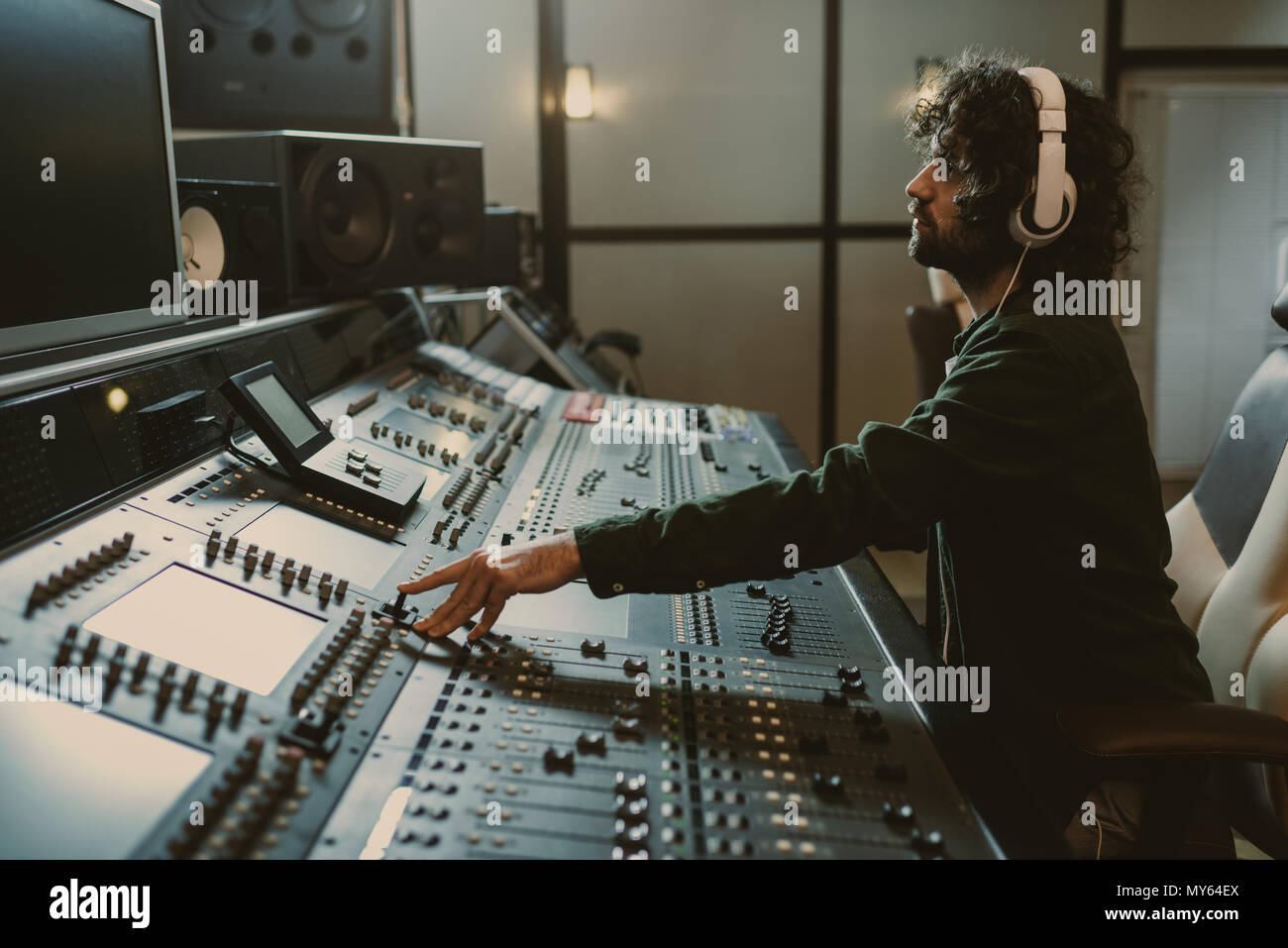side view of concentrated sound producer working at studio Stock Photo ...