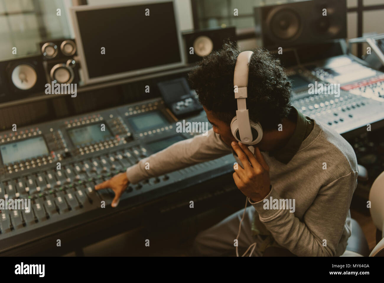 young african american sound producer working with analog equalizer at ...