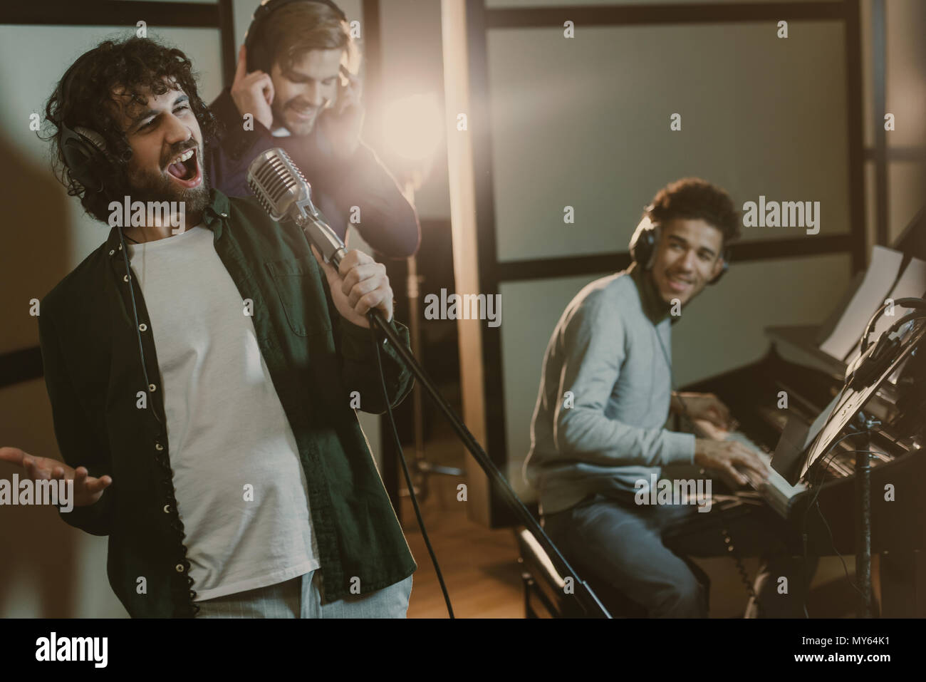band of musicians performing song at studio together Stock Photo - Alamy