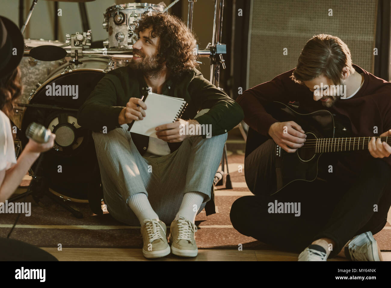 young music band sitting on floor with notepads and talking Stock Photo ...