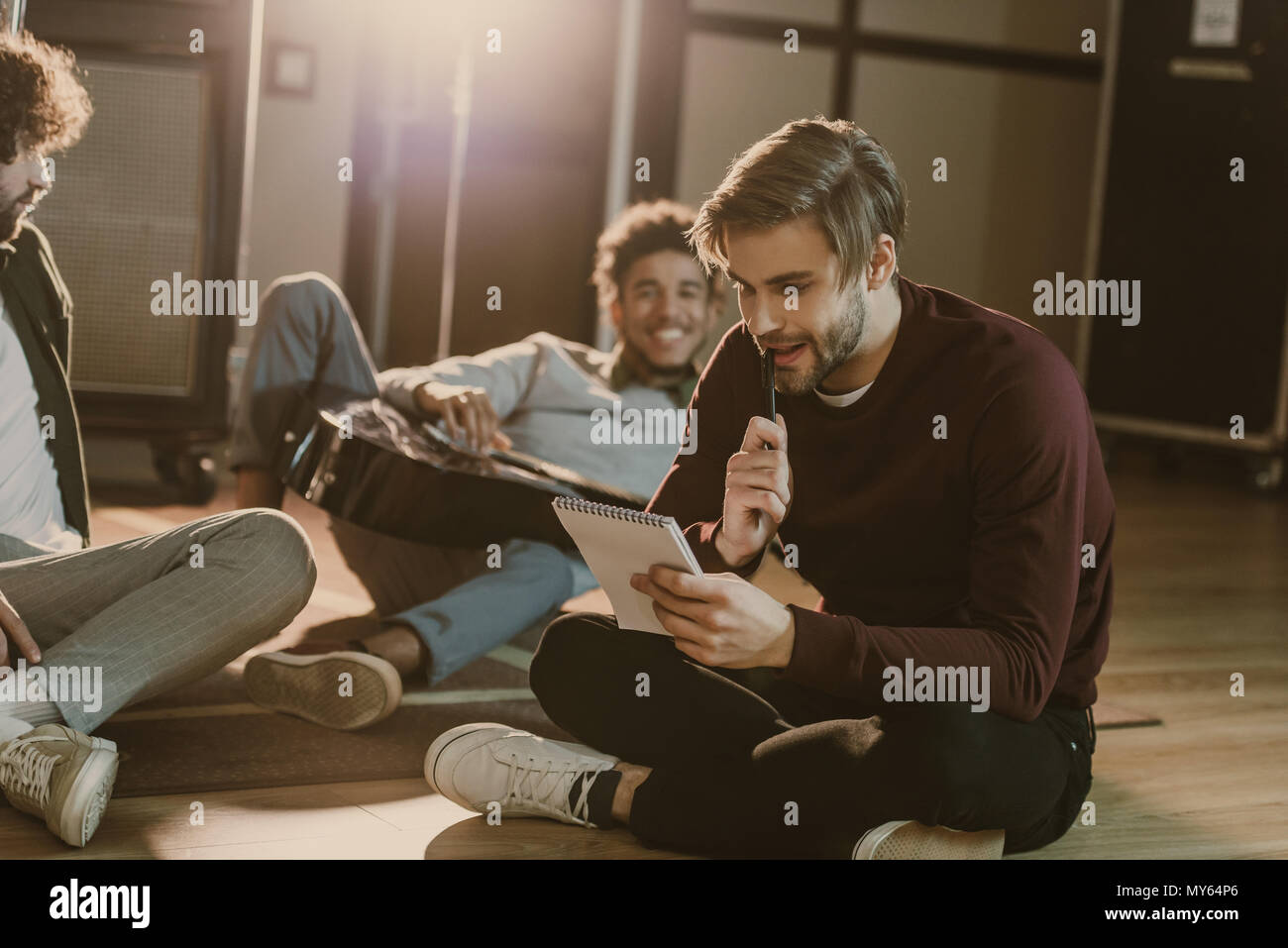 music band writing lyrics together while sitting on floor Stock Photo ...