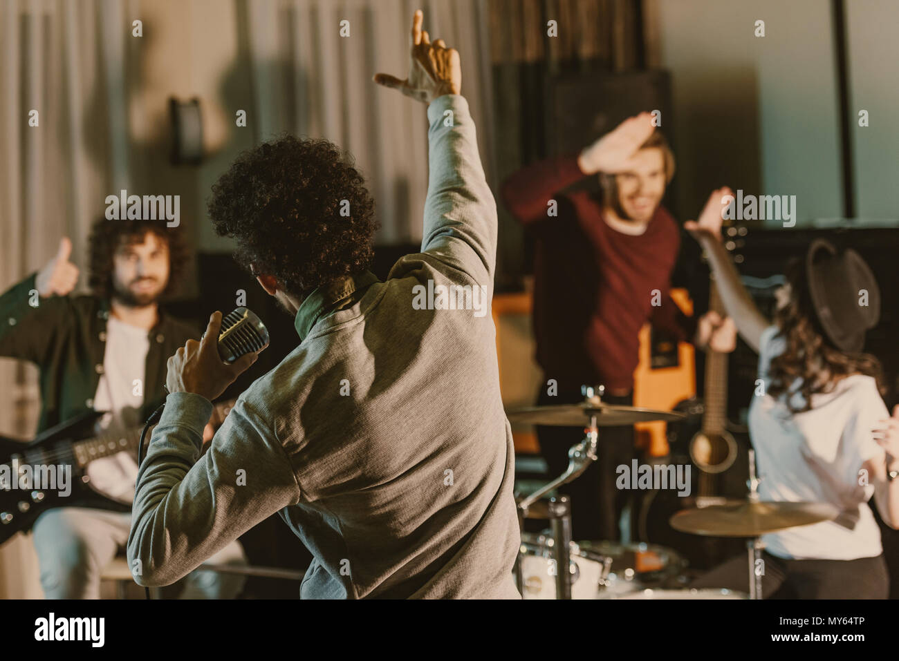 singer stretching hand to happy music band while they having repetition ...