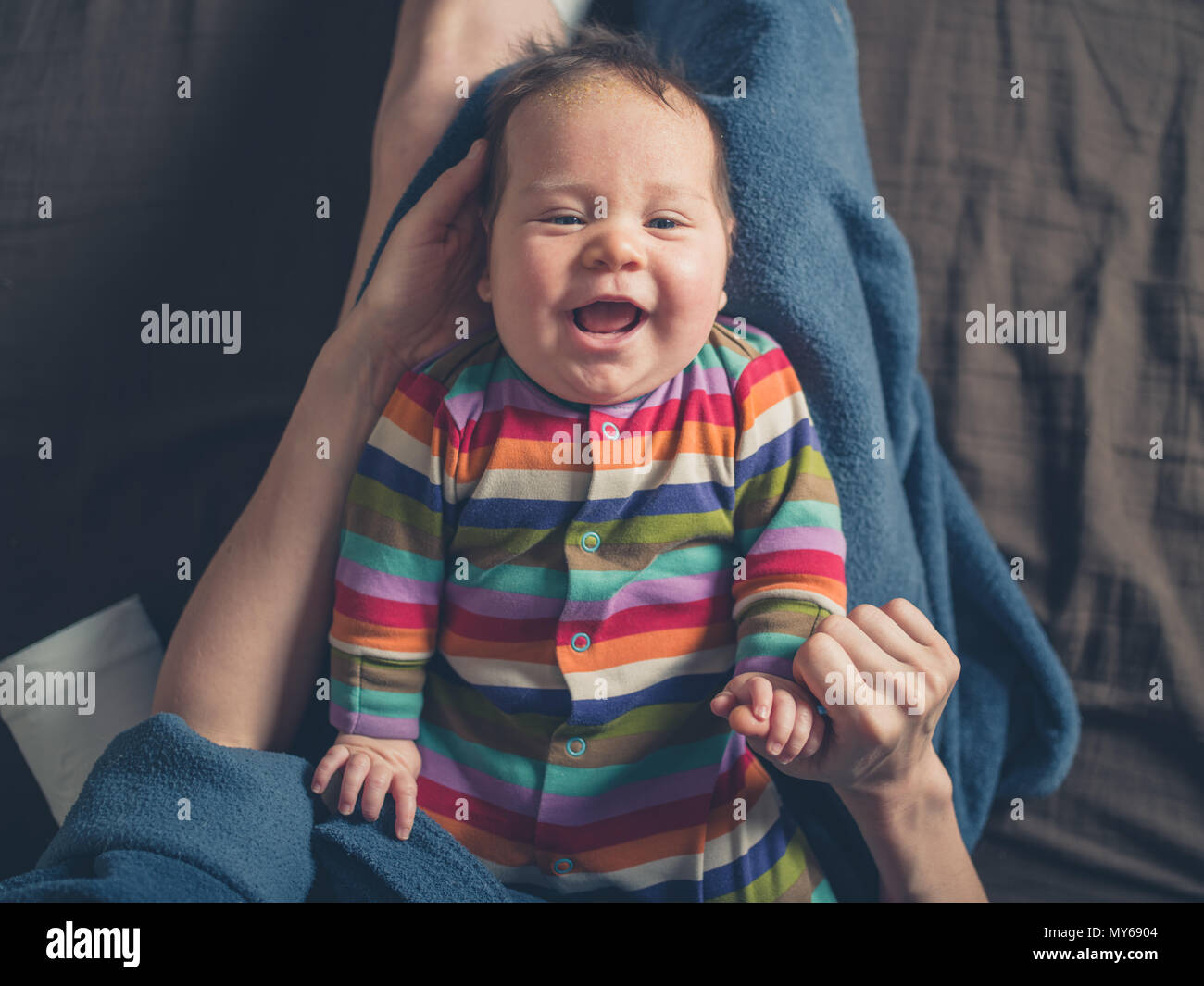 A happy laughing baby lying in the lap of his mother Stock Photo - Alamy