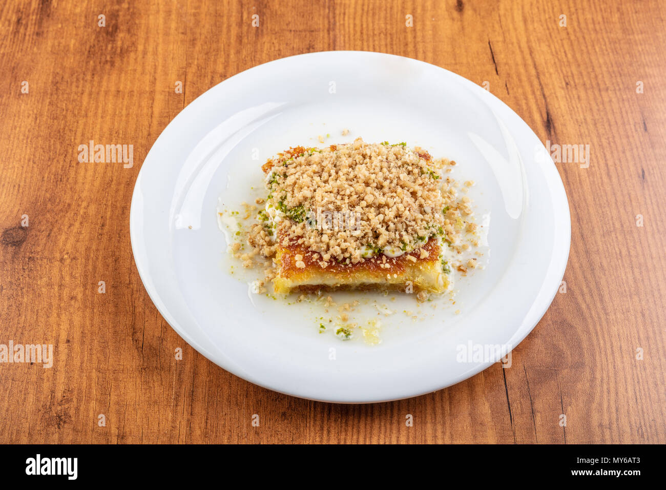Turkish dessert kunefe on kaymak, cream slide with pistachio powder ...