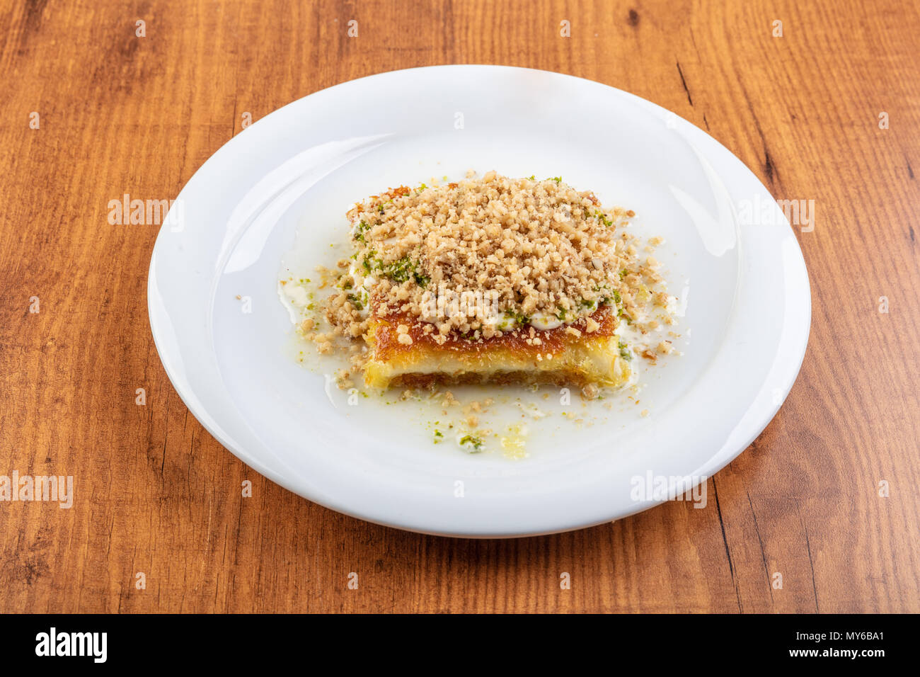 Turkish dessert kunefe on kaymak, cream slide with pistachio powder ...
