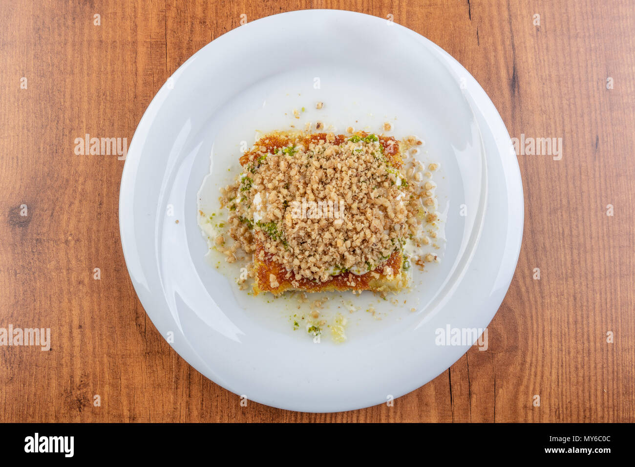 Turkish dessert kunefe on kaymak, cream slide with pistachio powder ...