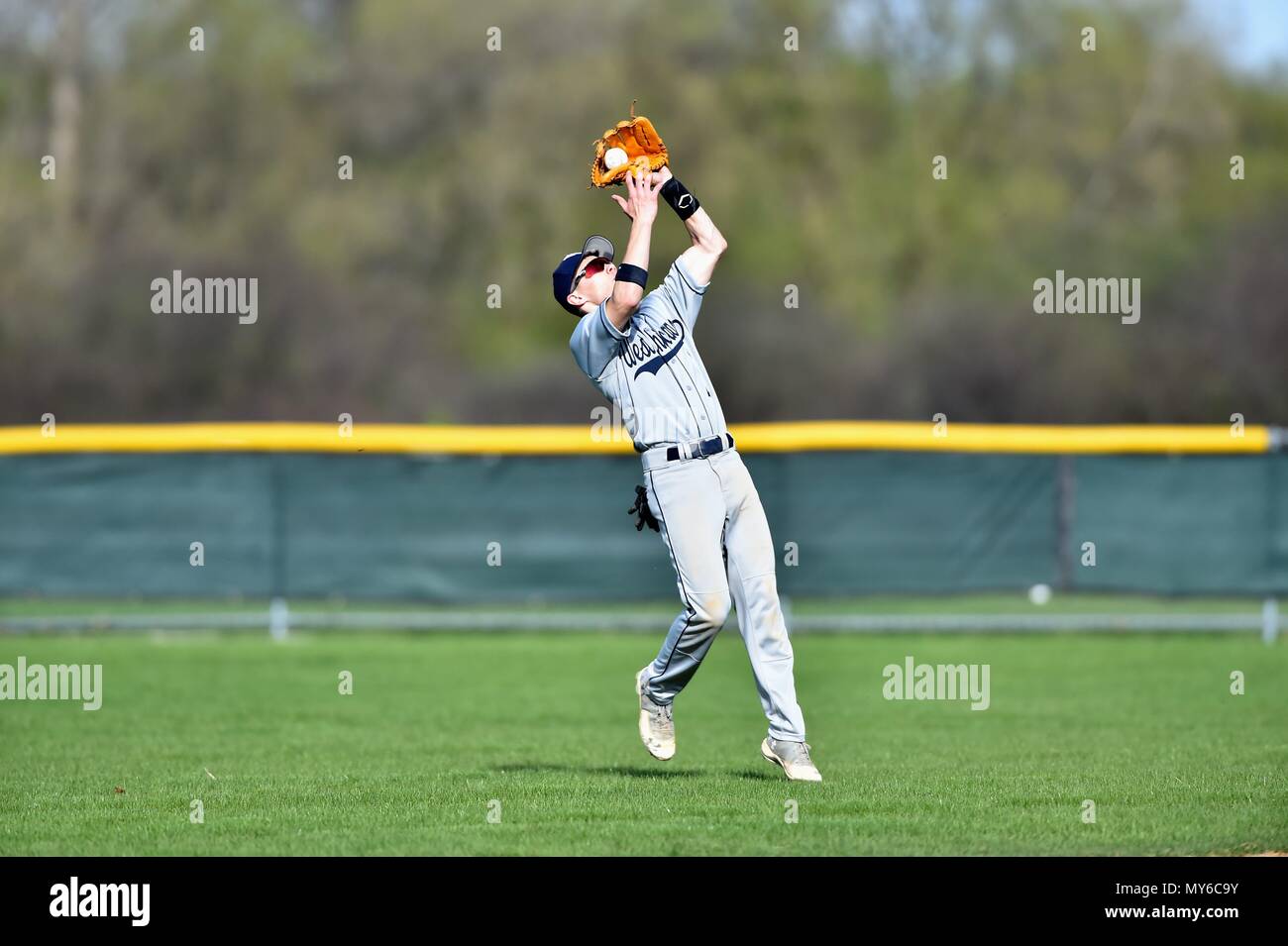 Shortstop making a catch of a wind-blown pop fly in short left-center ...