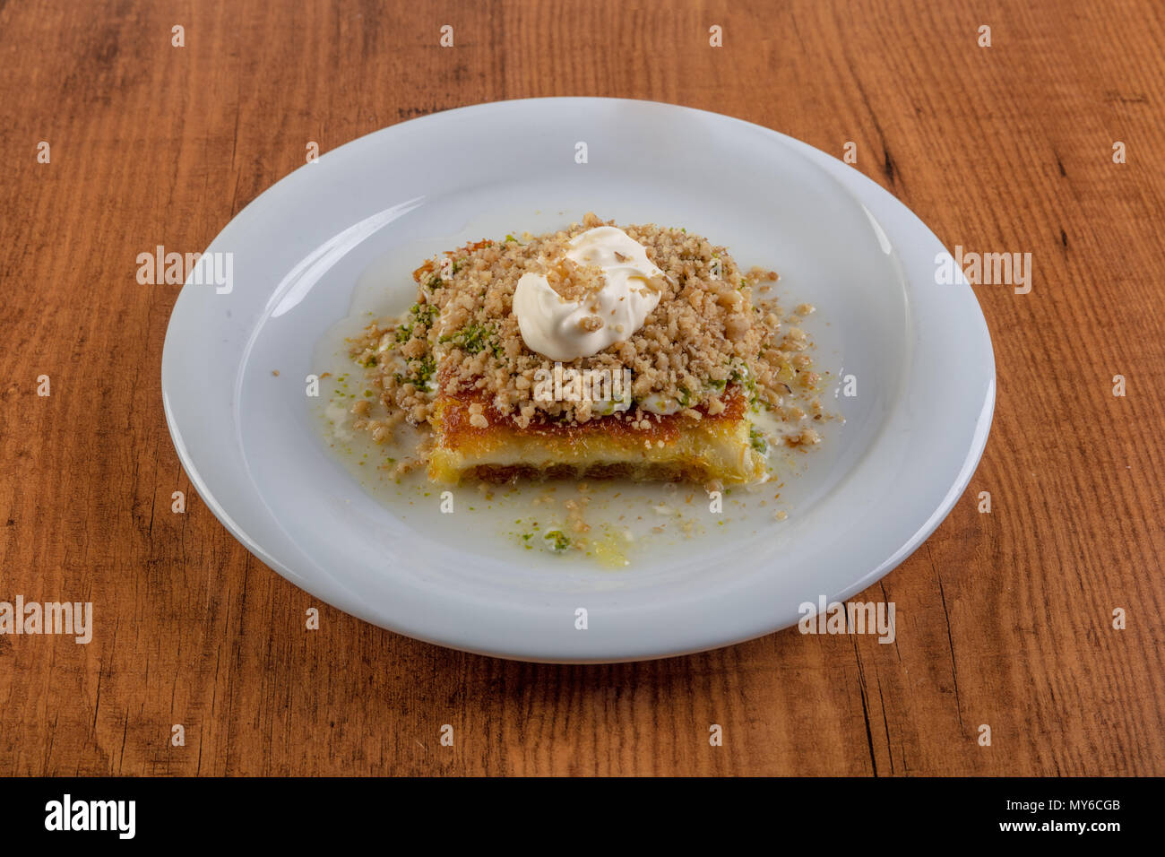 Turkish dessert kunefe on kaymak, cream slide with pistachio powder ...
