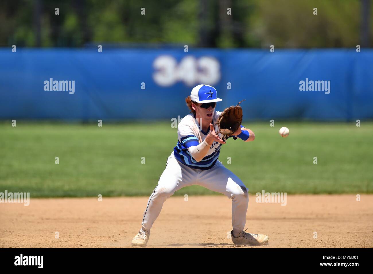 Third baseman fielding a ground ball on a high hop prior to throwing on ...