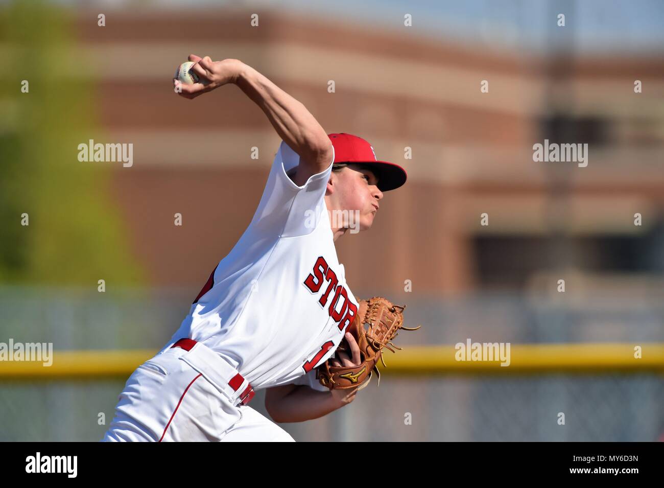 Pitcher throwing a pitch to a waiting hitter on his way to throwing a ...