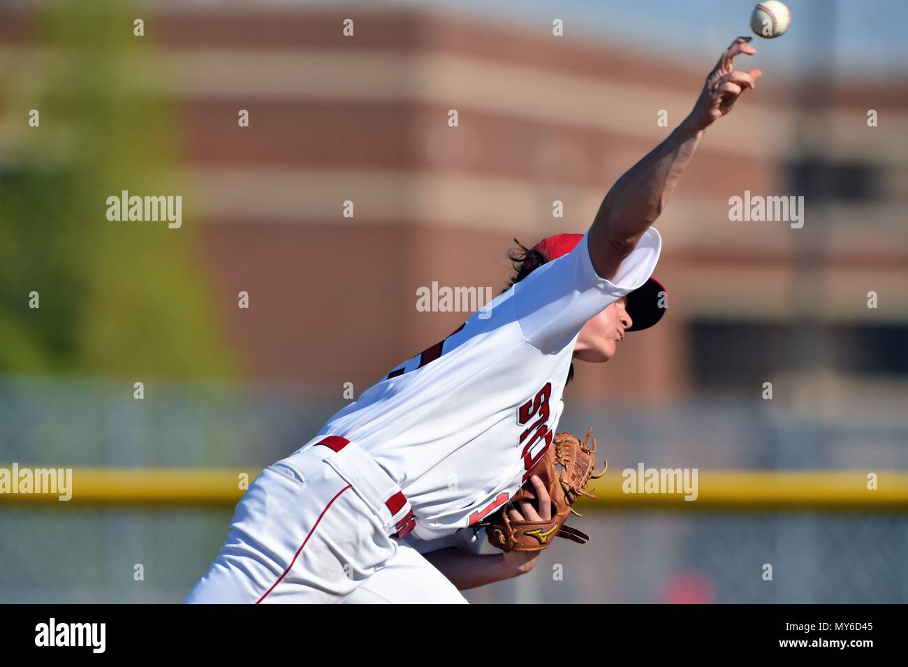 Pitcher releasing a pitch to a waiting hitter on his way to throwing a ...