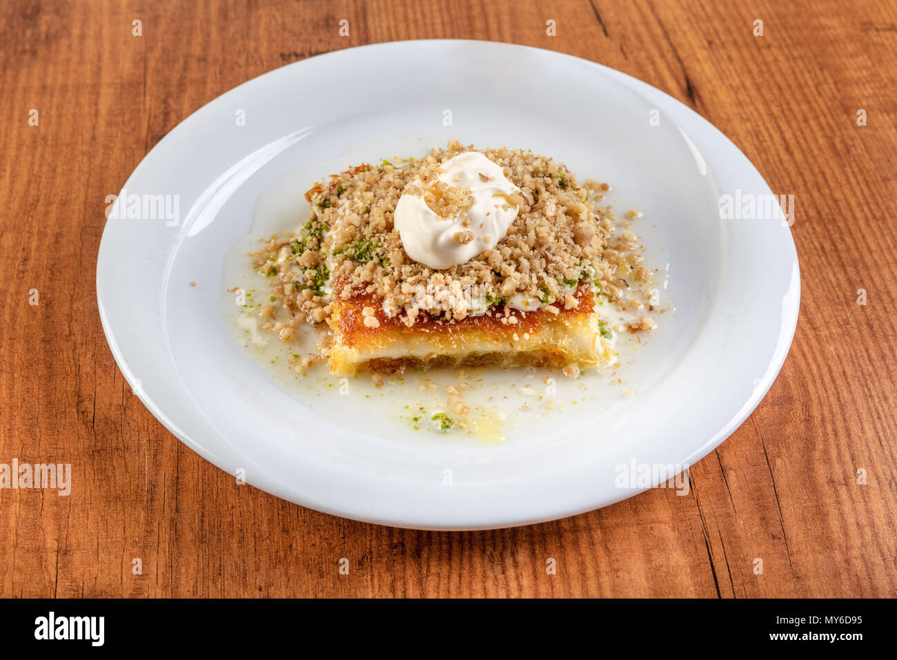 Turkish dessert kunefe on kaymak, cream slide with pistachio powder ...