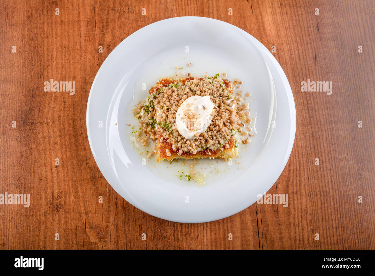 Turkish dessert kunefe on kaymak, cream slide with pistachio powder ...