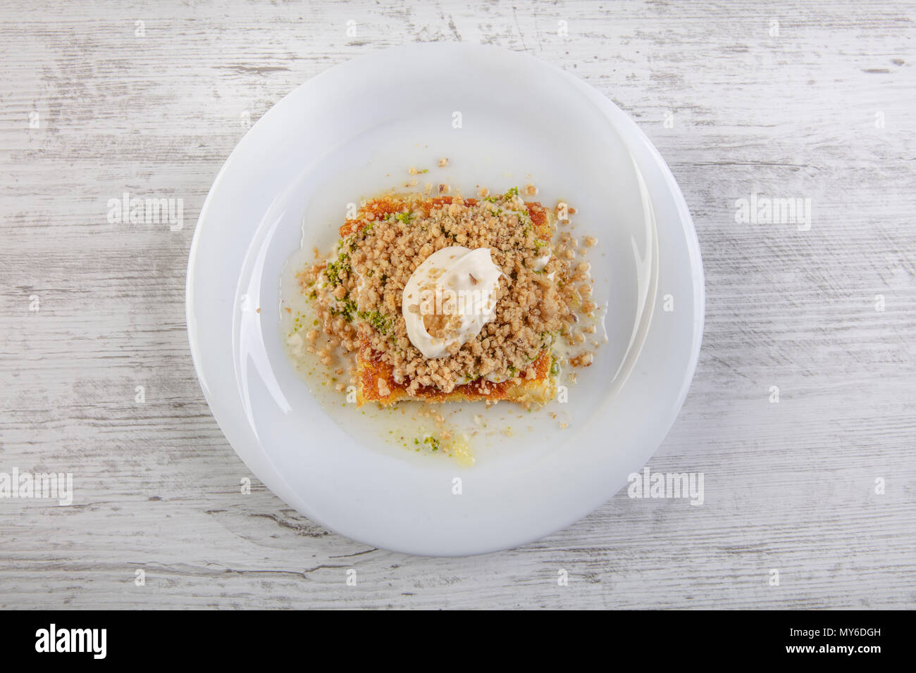 Turkish dessert kunefe on kaymak, cream slide with pistachio powder ...