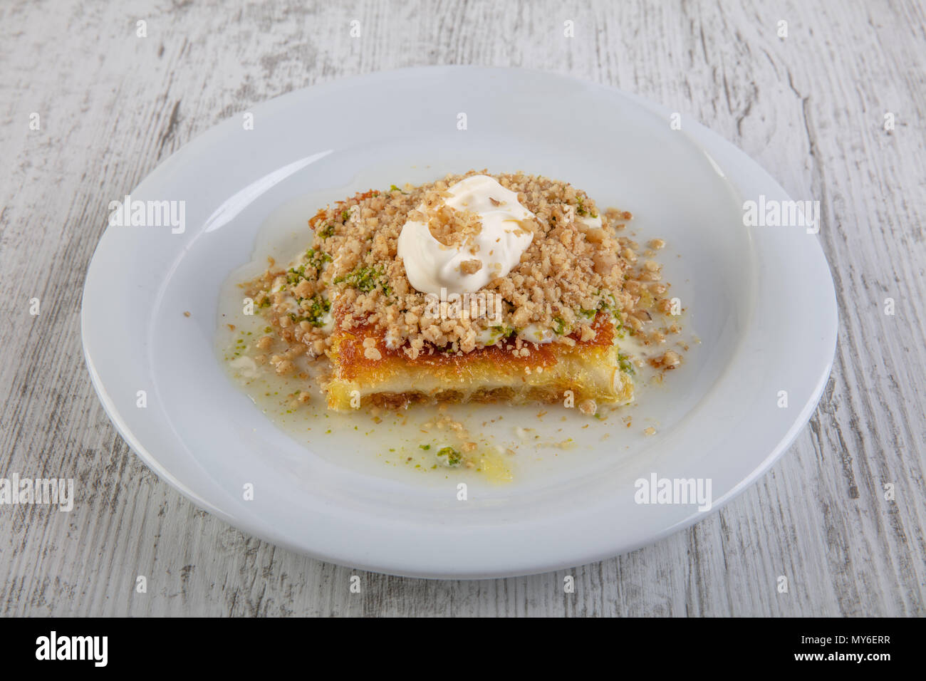 Turkish dessert kunefe on kaymak, cream slide with pistachio powder ...