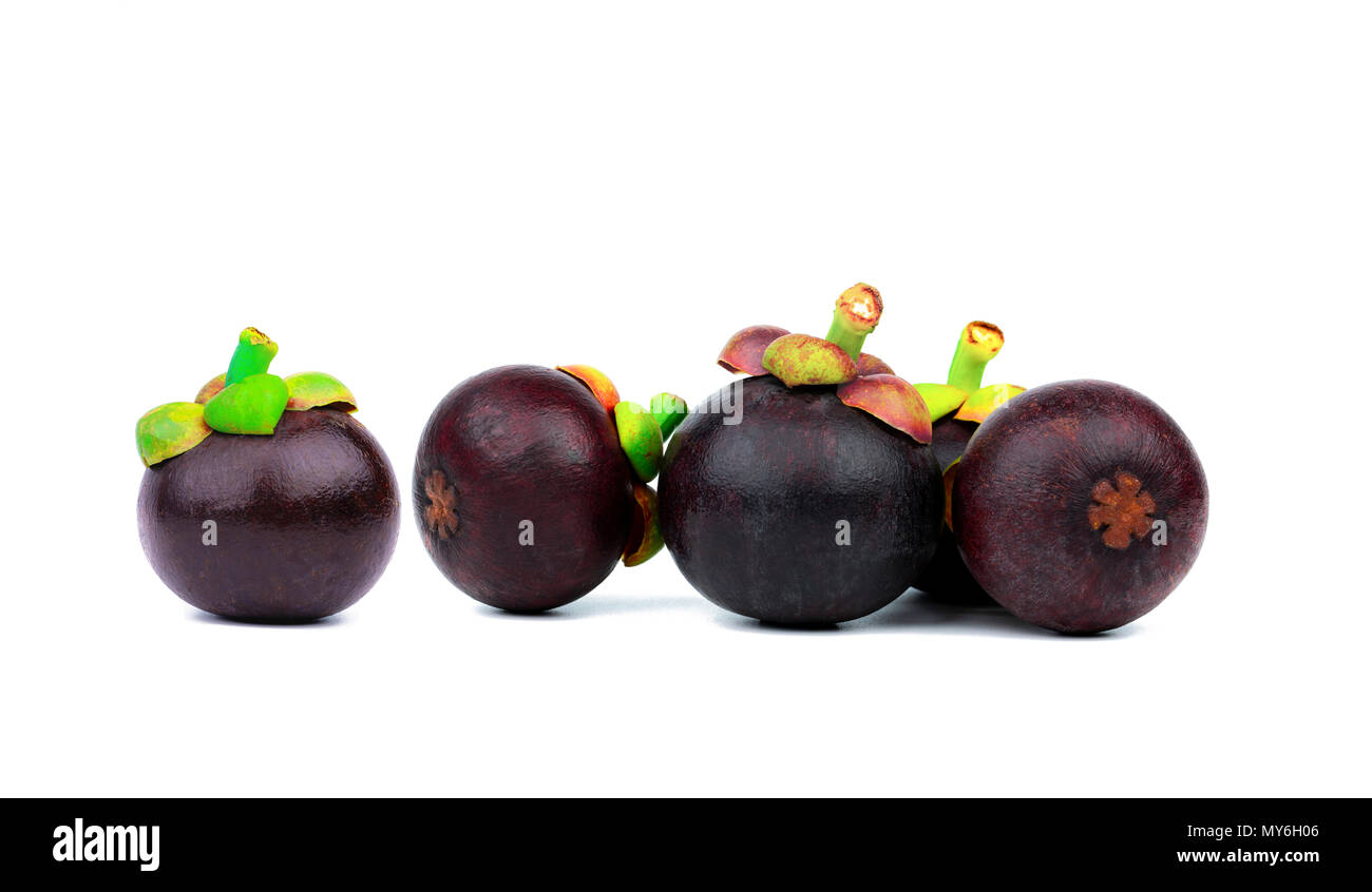 Whole mangosteen showing purple skin isolated on white background with ...