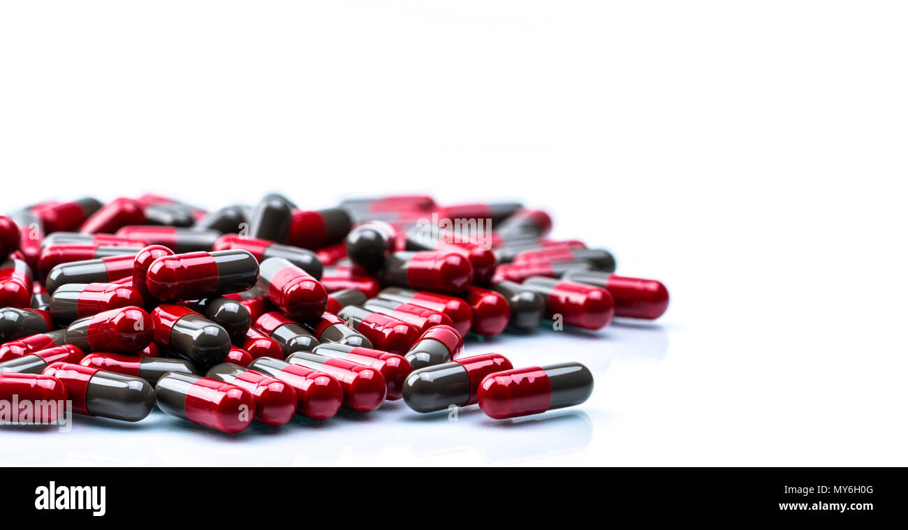 Pile of red and grey capsule pills isolated on white background with ...
