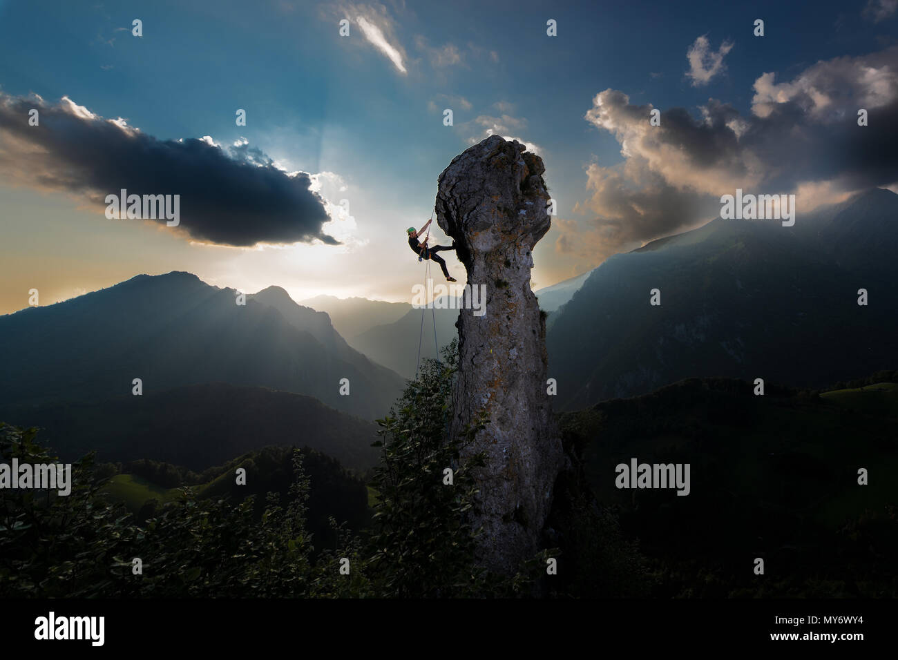 Double rope rappelling of a climber from the tip of a rock in a ...
