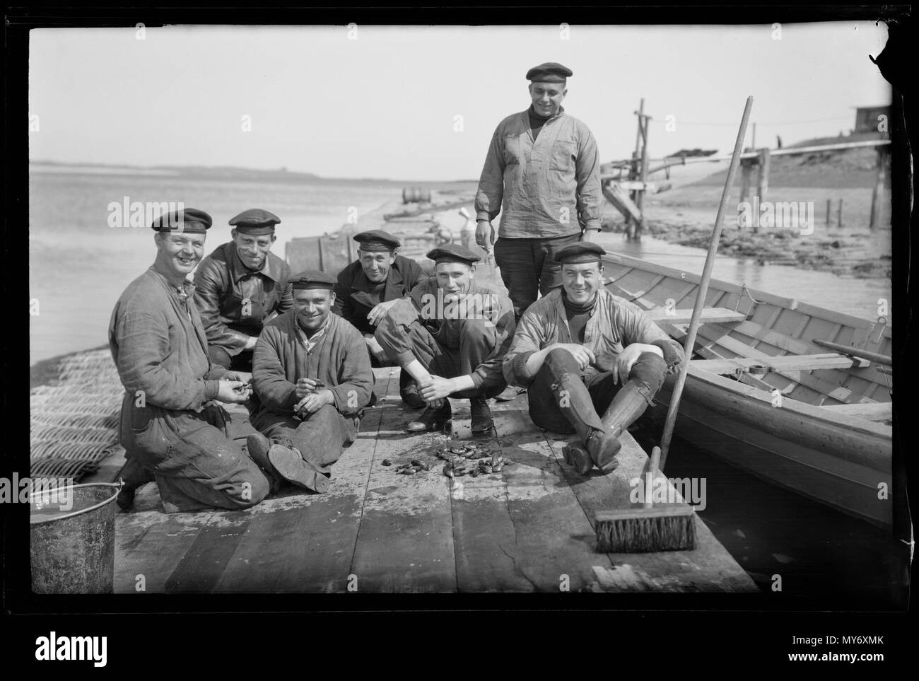 Matrozen. Groepsfoto met matrozen op een steiger rond een kleine vangst ...