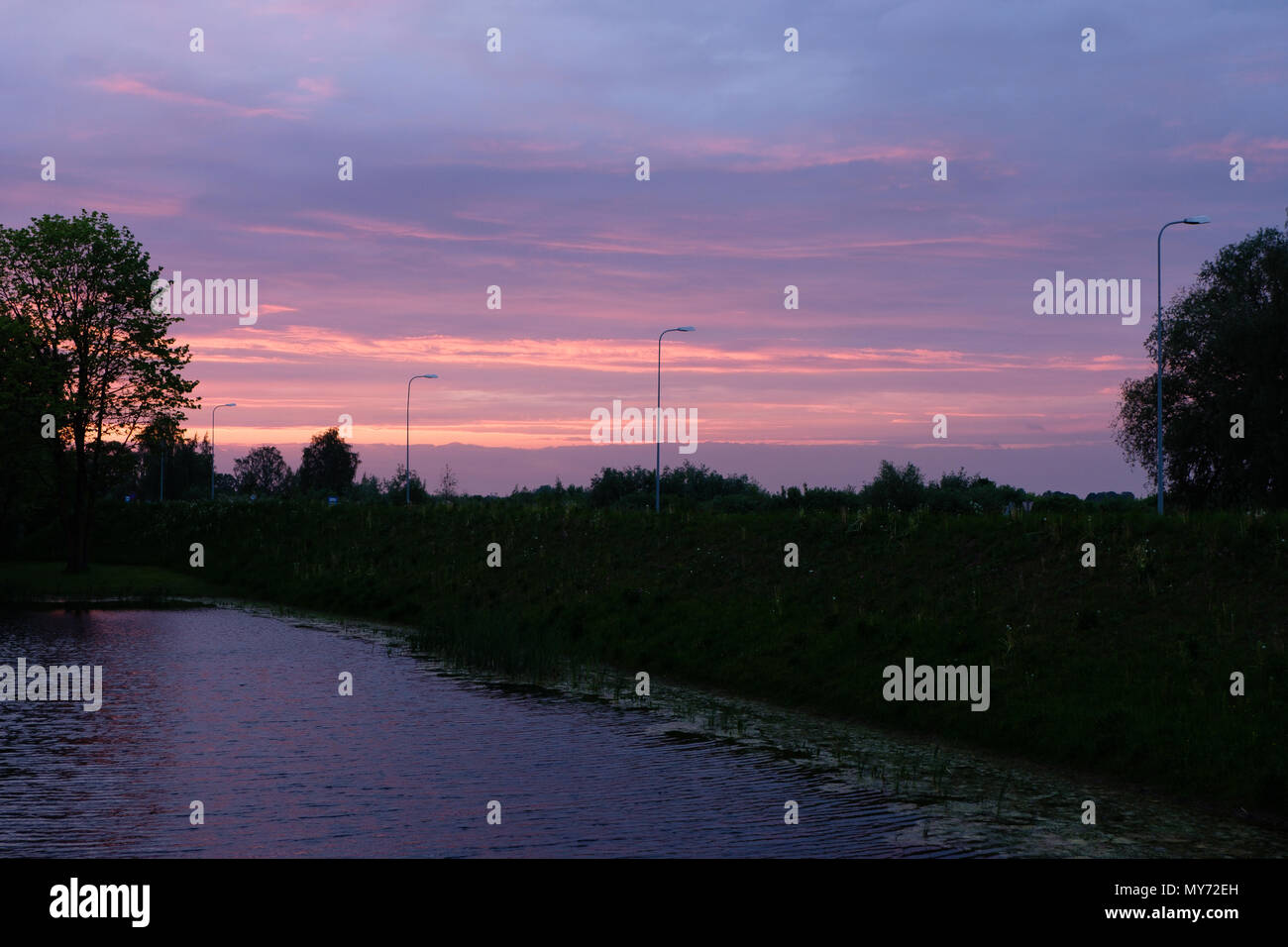 dramatic sunrise over the calm country side trees in forest. latvia ...