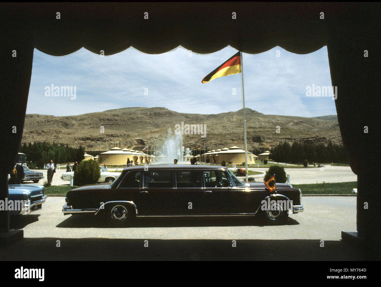 A limousine with a German pennant in front of a flagpole flying the ...