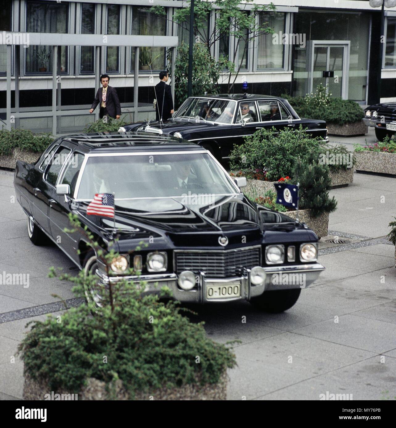 A US limousine with US flags followed by a Mercedes with a blue light ...