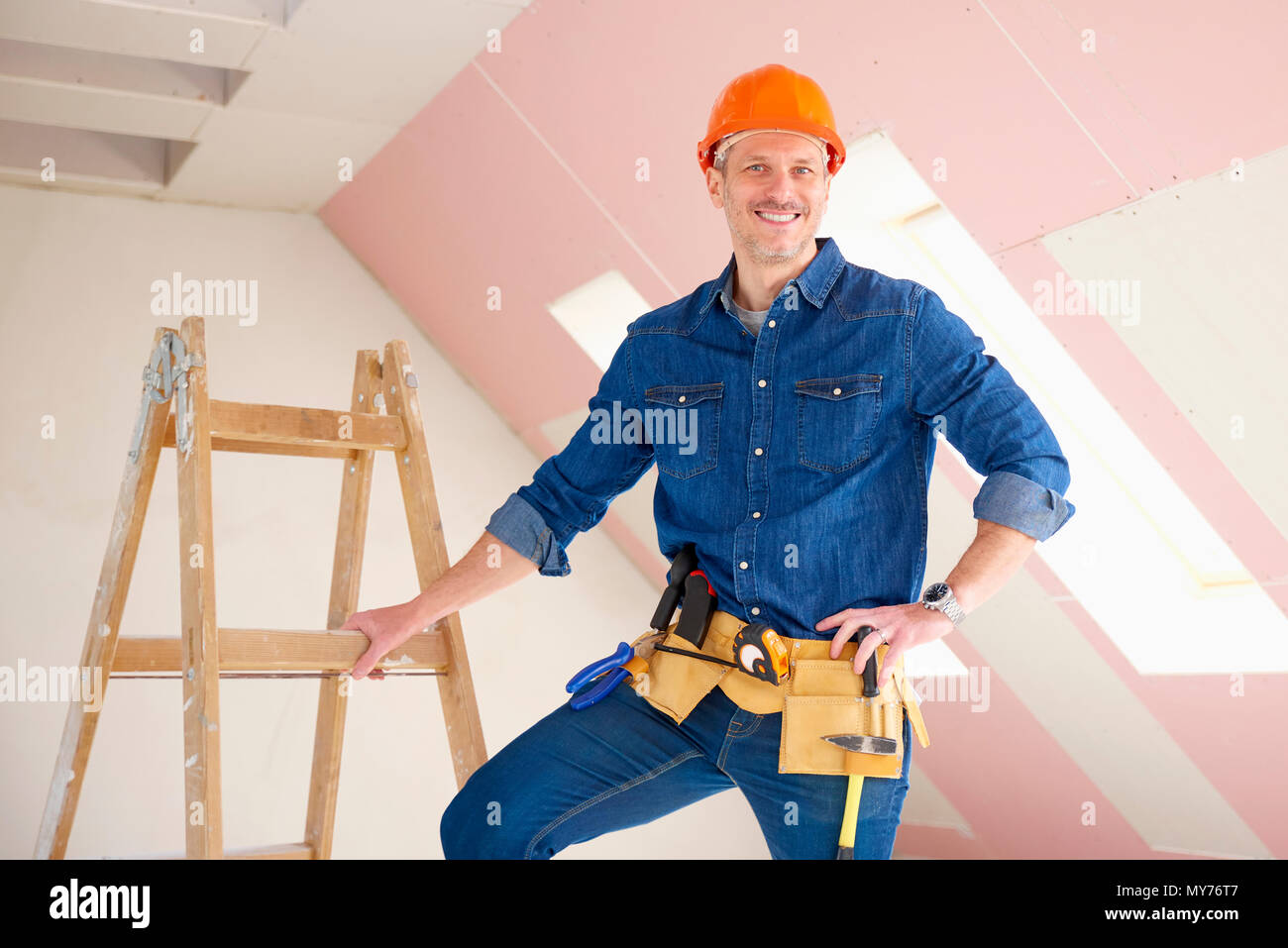Confident middle aged handyman standing at construction site Stock ...