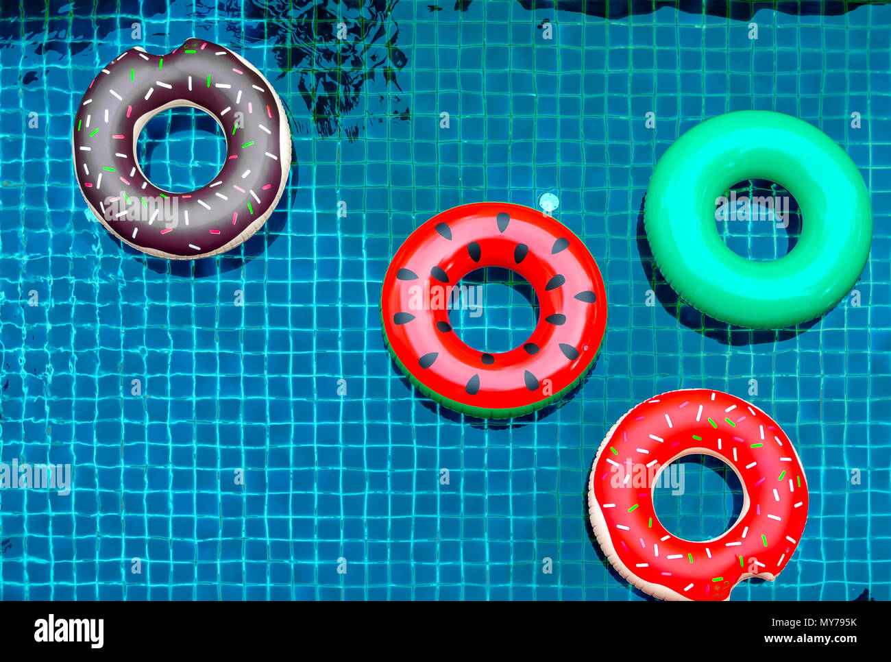Colorful Pool Float Rings are Floating on Swimming Pool Background ...