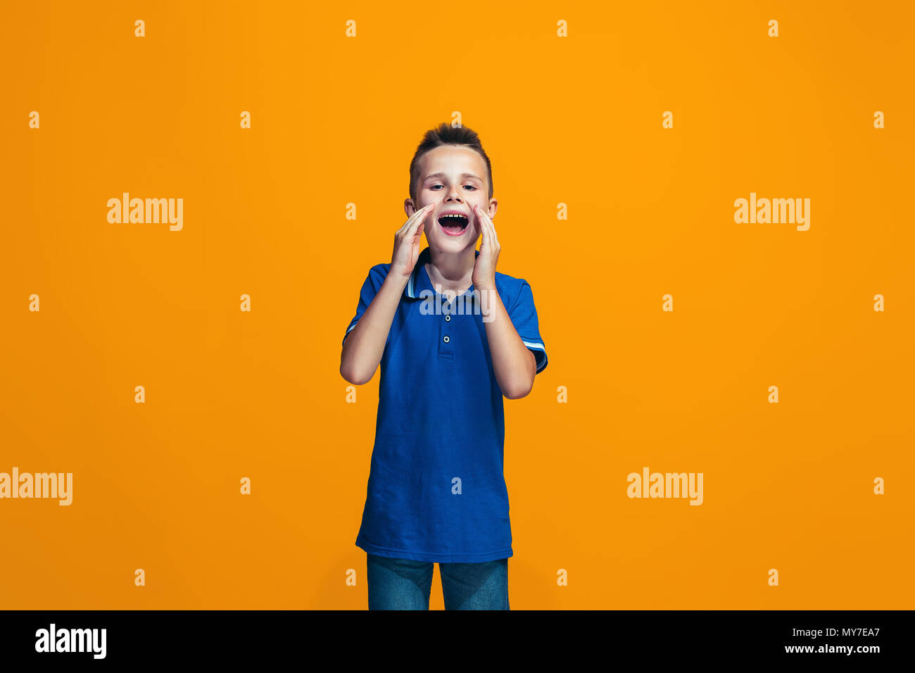 Isolated on orange young casual teen boy shouting at studio Stock Photo ...