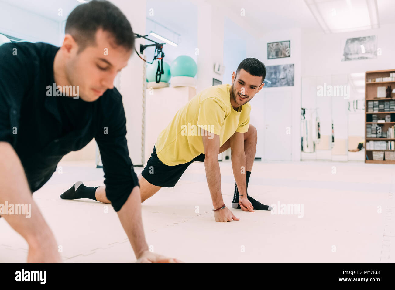Men in gym doing stretching exercises Stock Photo - Alamy