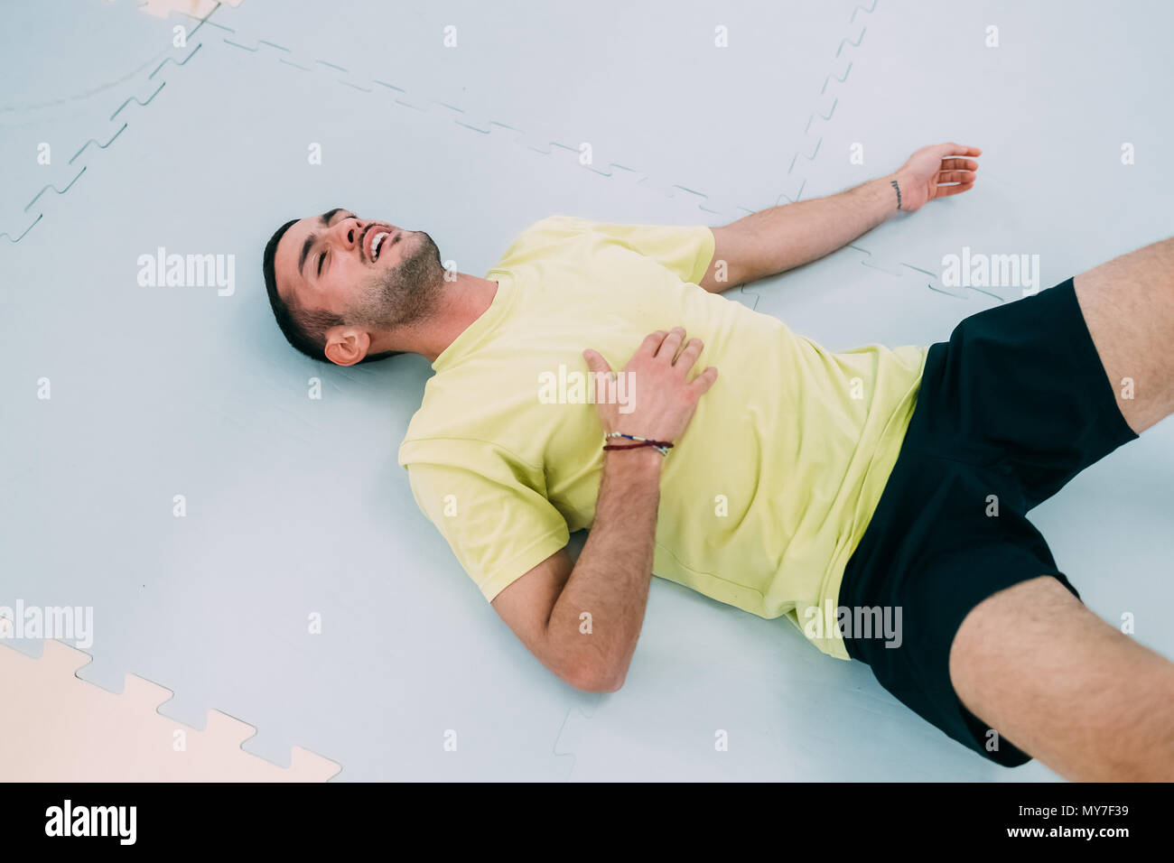 Exhausted man lying on floor on back Stock Photo - Alamy