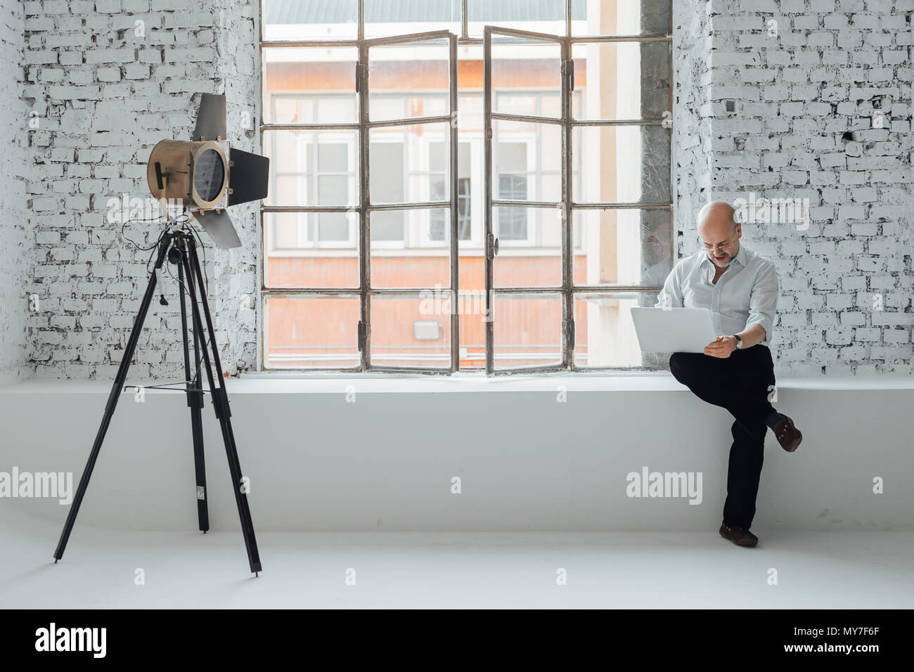 Man sitting on window ledge hi-res stock photography and images - Alamy
