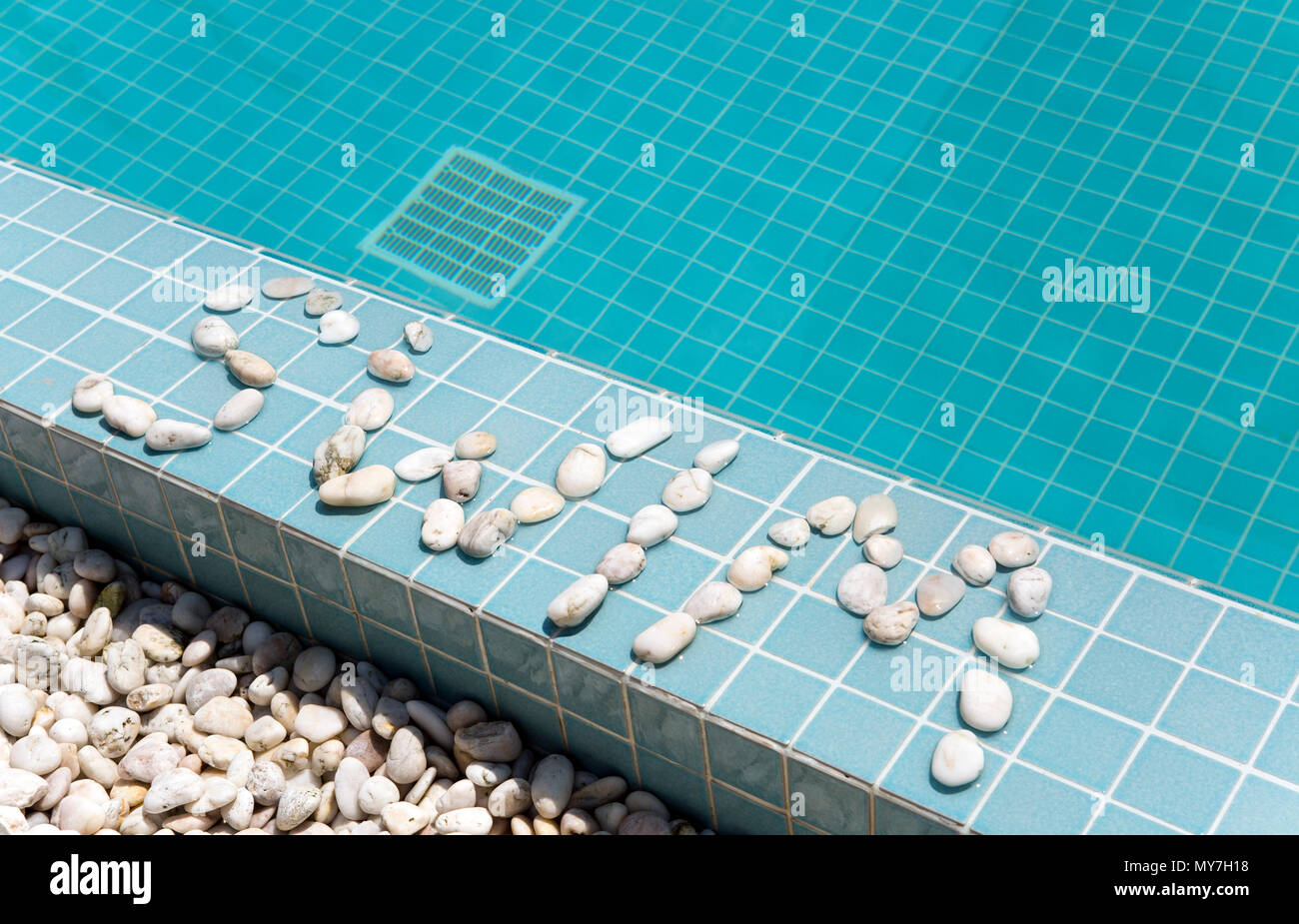 The inscription " swim " is laid out by pebble on a pool side Stock ...