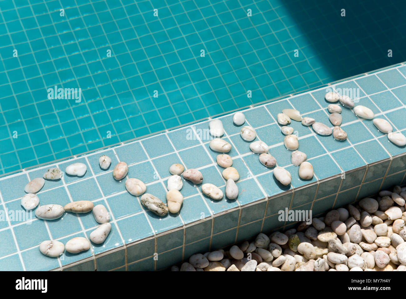 The inscription " swim " is laid out by pebble on a pool side Stock ...