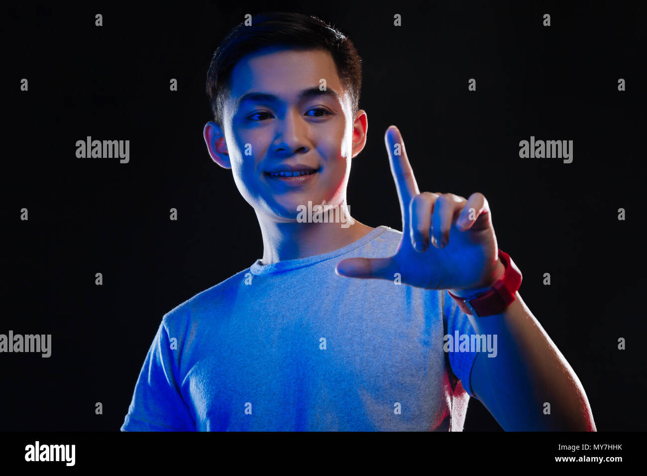 Cheerful positive man looking at his finger Stock Photo - Alamy Cheerful positive man looking at his finger Stock Photo - Alamy