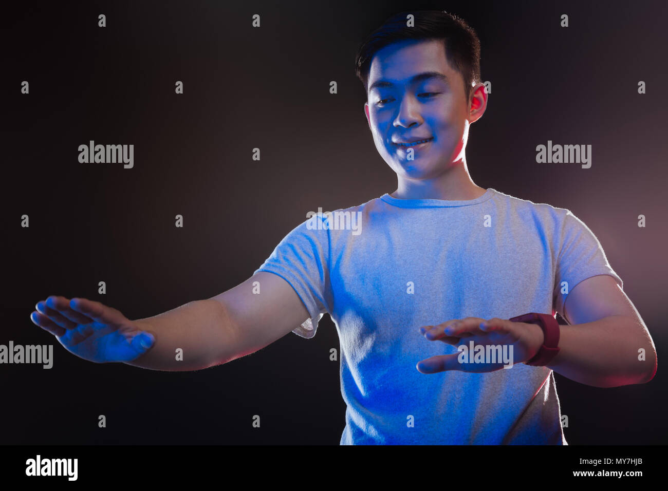 Pleasant young man looking at his hands Stock Photo - Alamy
