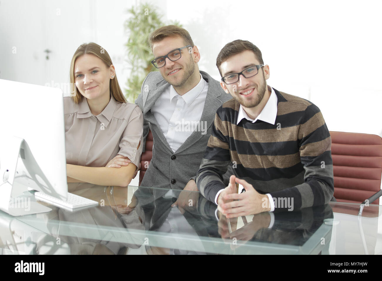 smiling business team sitting at the Desk Stock Photo - Alamy