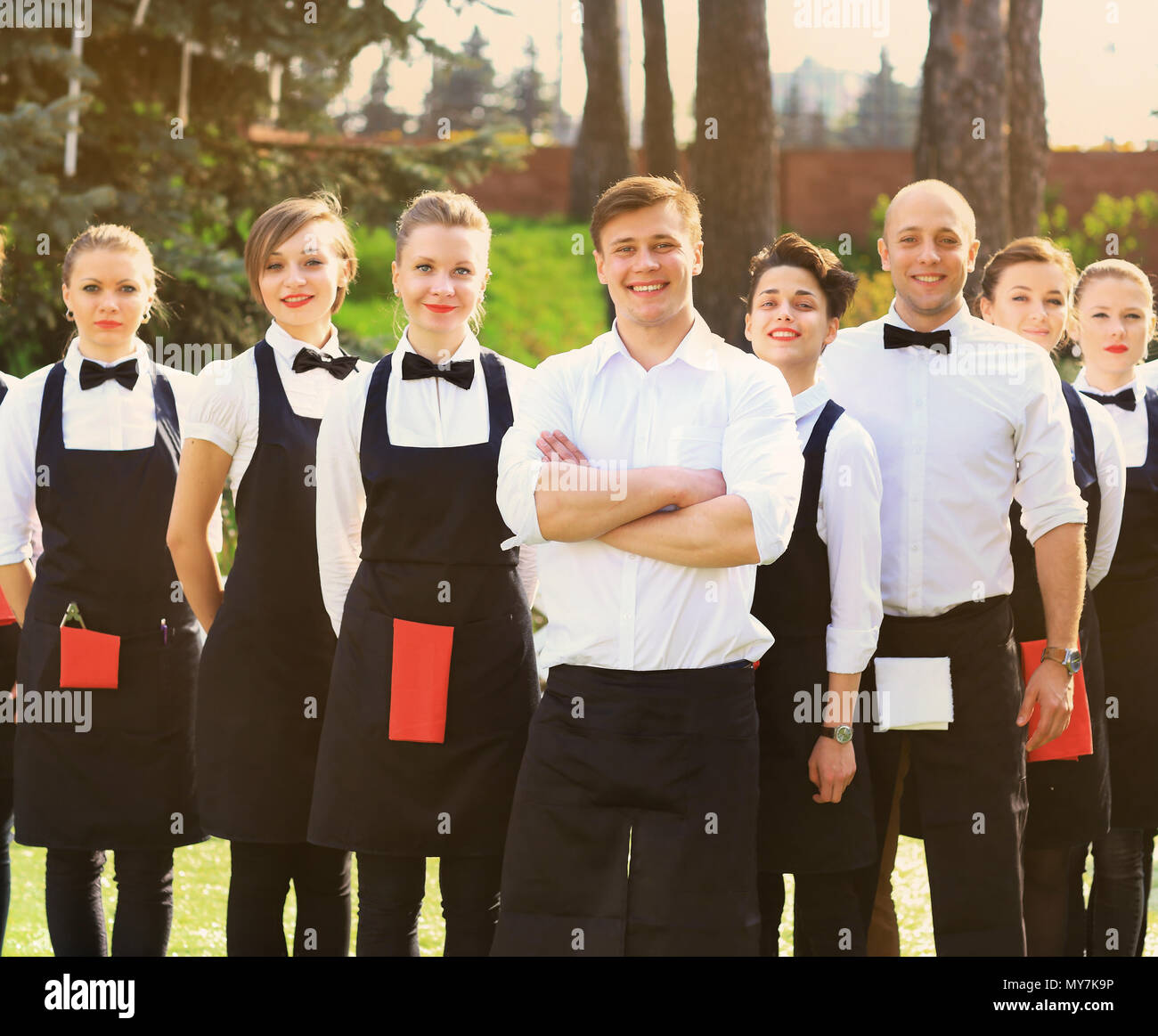 large group of cooks and waitresses stand in a row behind the chef ...