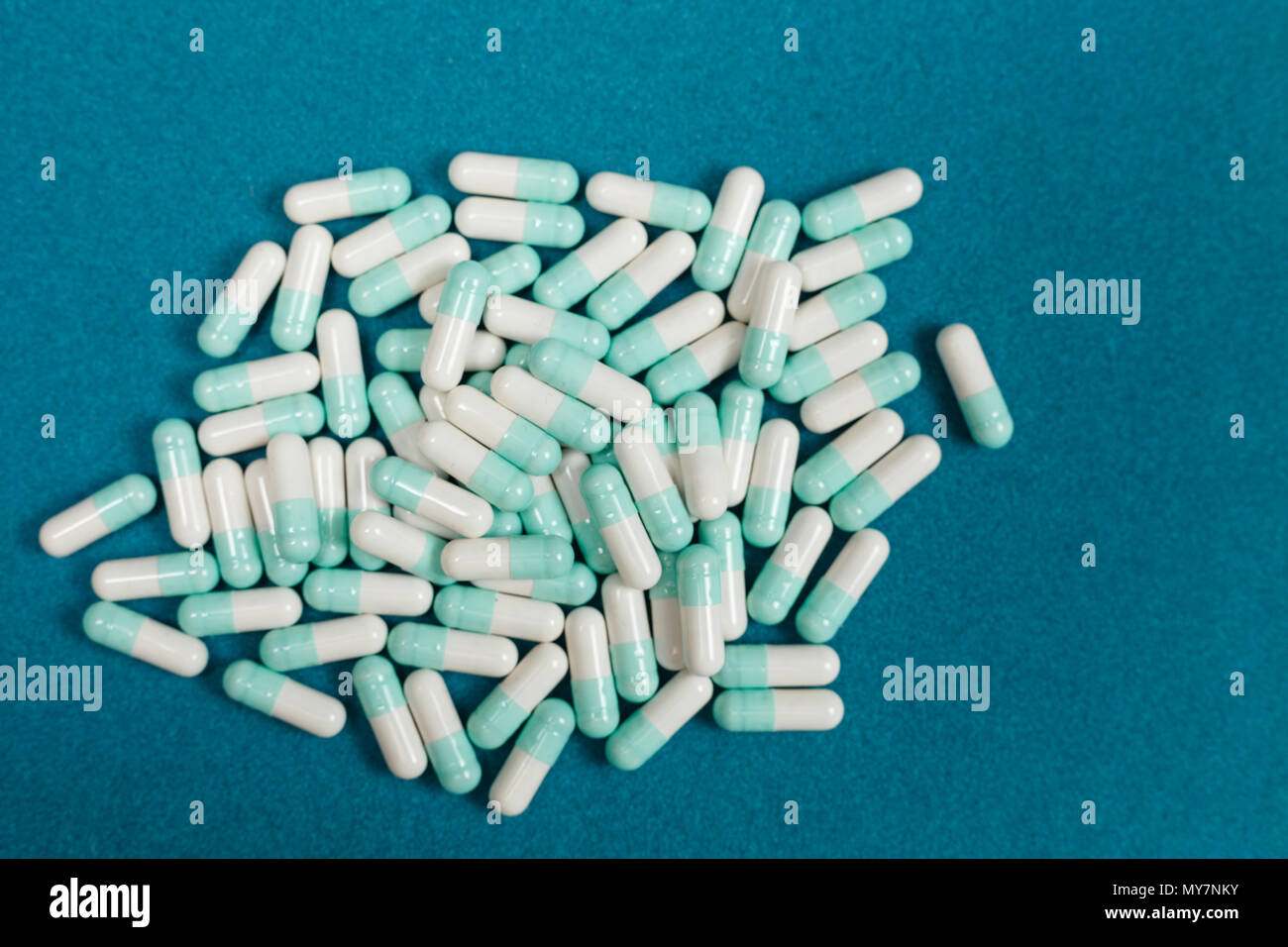Assorted pharmaceutical medicine pills, tablets and capsules over blu ...