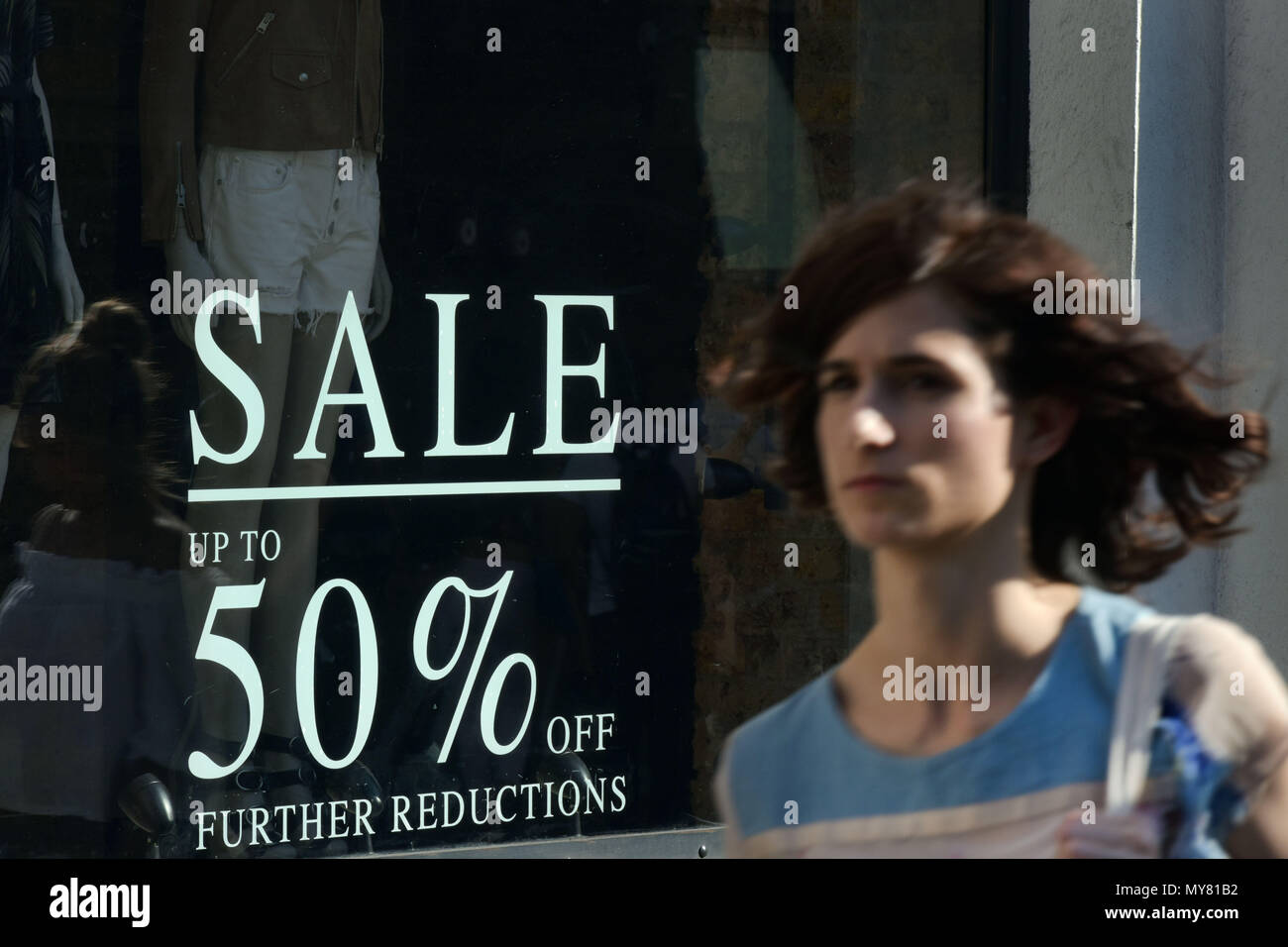 Tourists and shoppers walk past the shops with 50% further reduction ...