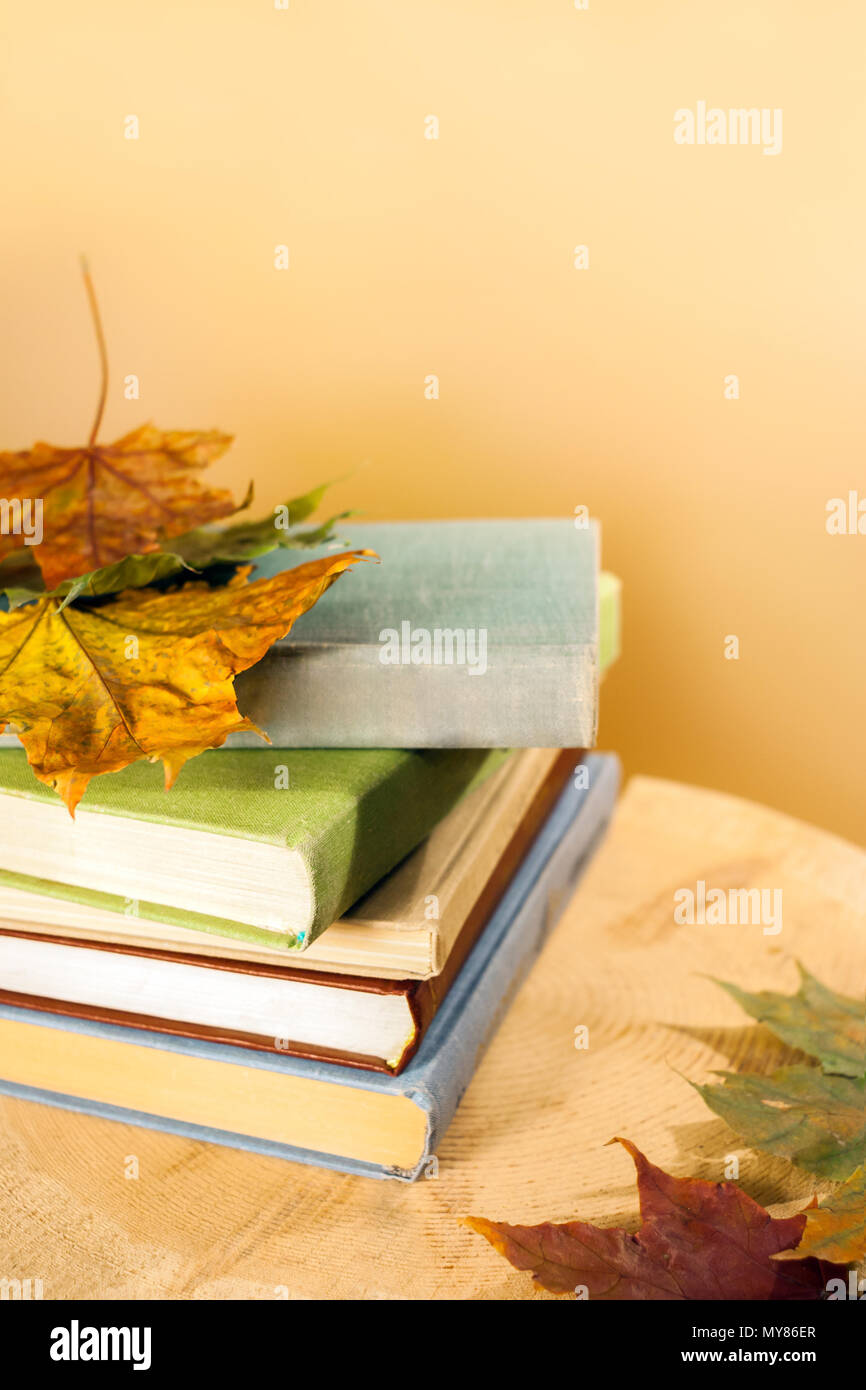 Stack of books with autumn leaves on wooden cut. Back to school concept ...