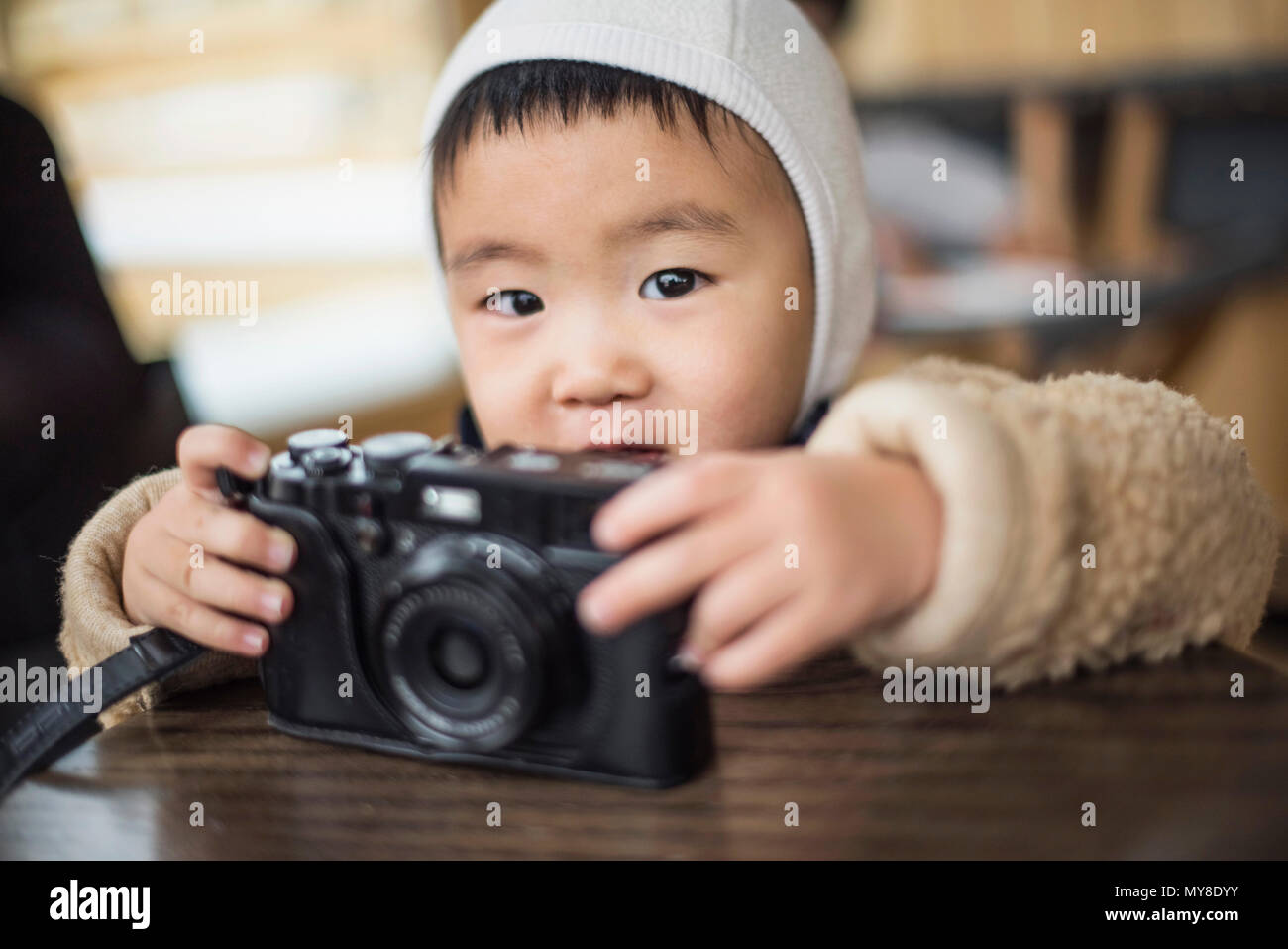 Little boy holding camera on table Stock Photo - Alamy
