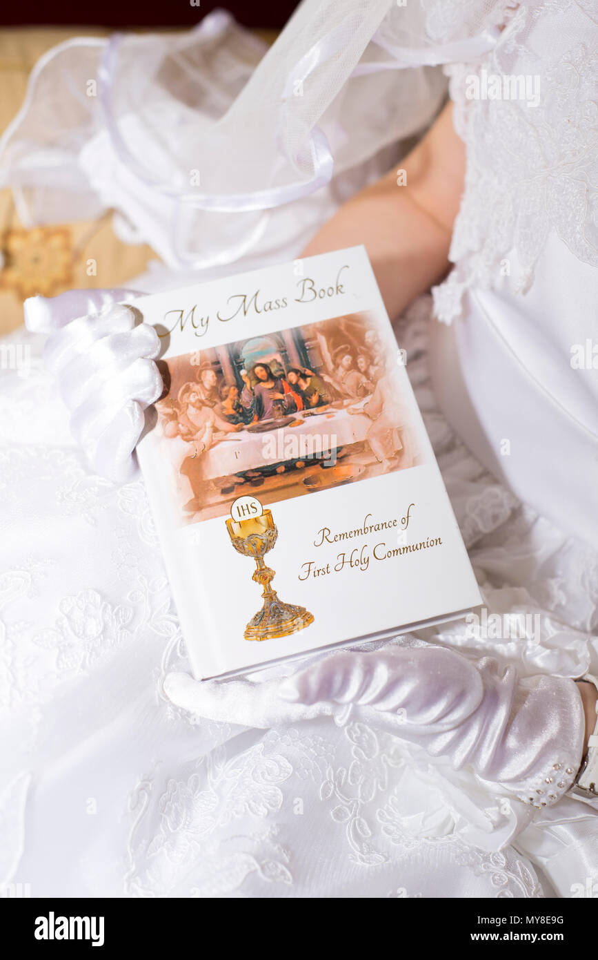 young girls hands holding her communion book Stock Photo - Alamy