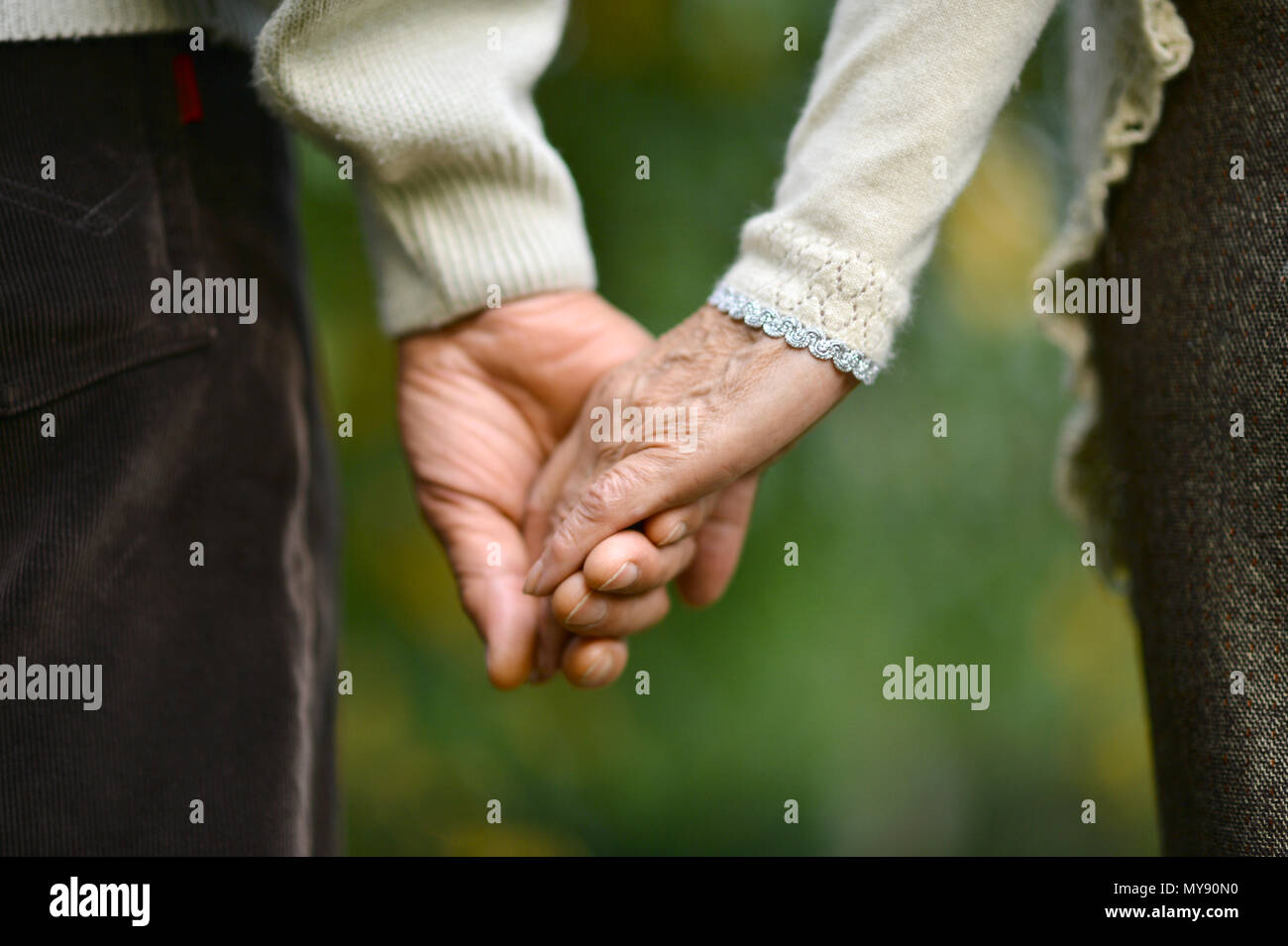 Elderly couple holding hands together Stock Photo - Alamy