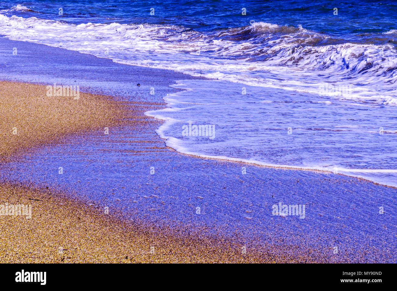 close up of the sea water affecting the sand on the beach, sea waves ...