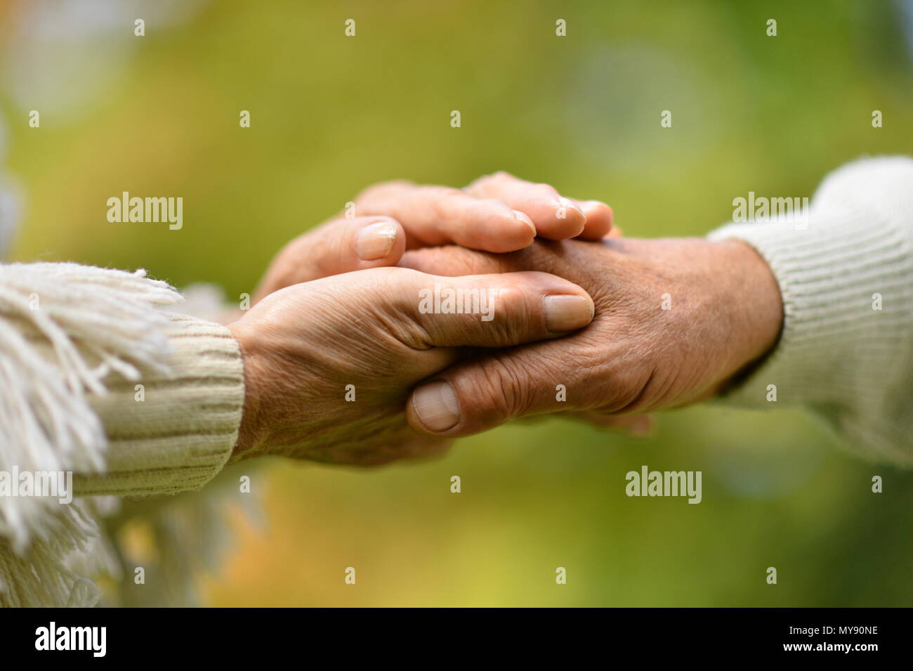 Elderly couple holding hands Stock Photo - Alamy