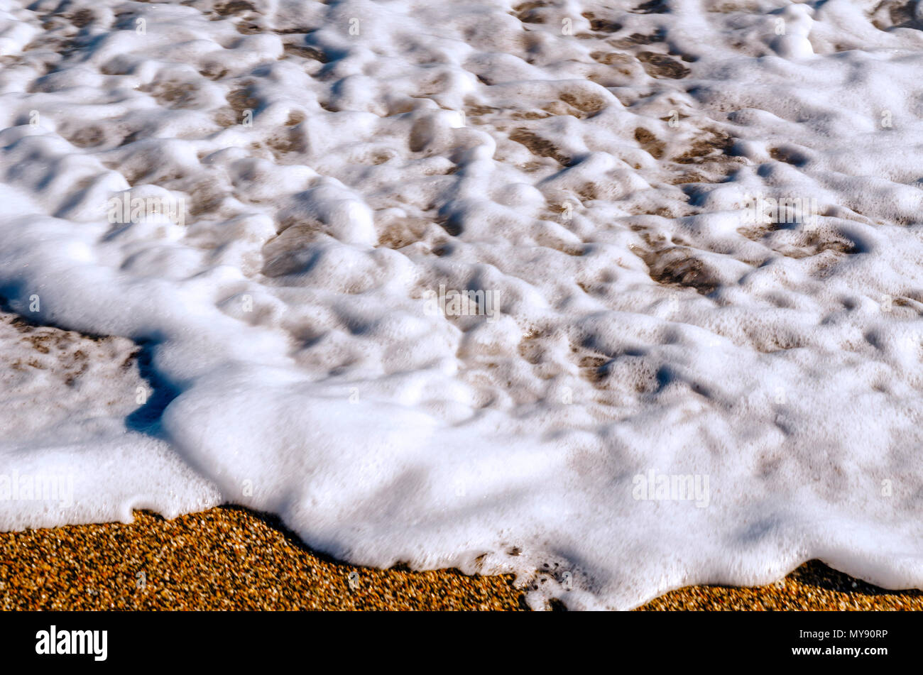 close up of the sea water affecting the sand on the beach, sea waves ...