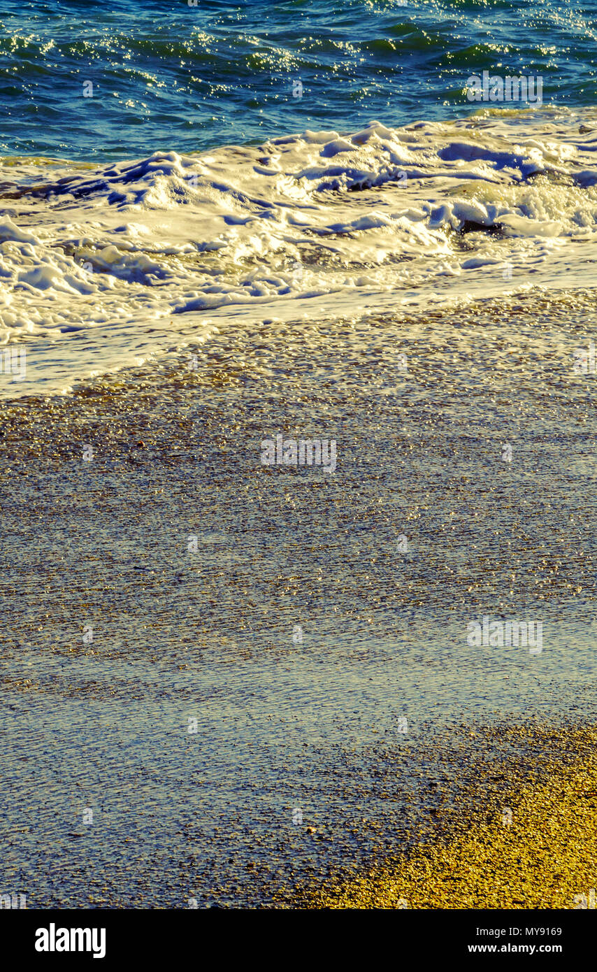 close up of the sea water affecting the sand on the beach, sea waves ...