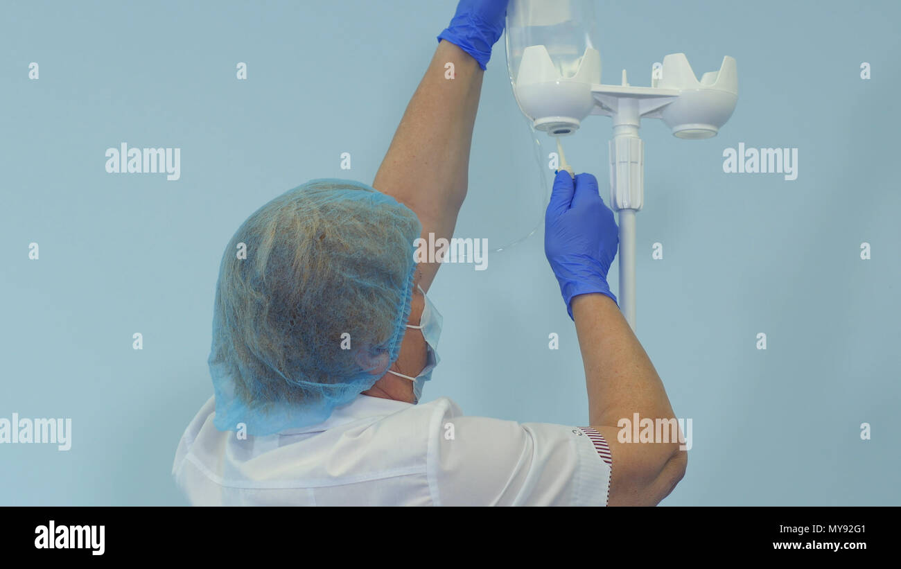 Nurse in mask and gloves preparing IV drip stand Stock Photo - Alamy